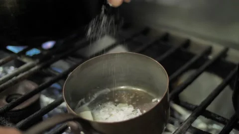 Chef adding salt to frying onion and but... | Stock Video | Pond5