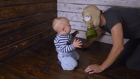 child and father in a gas mask hd | Stock Video | Pond5