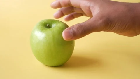 child boy hand hold a apple on yellow ba... | Stock Video | Pond5