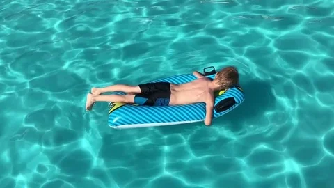 Child boy relaxes on an inflatable boat ... | Stock Video | Pond5