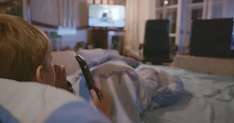 Child Boy Watch TV Set Lying on Bed. Lon... | Stock Video | Pond5