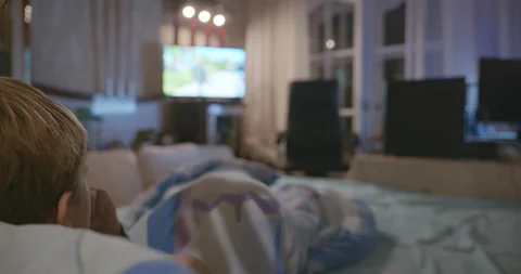 Child Boy Watch TV Set Lying on Bed. Lon... | Stock Video | Pond5