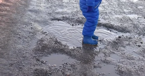 Child in bright blue overalls and rubber... | Stock Video | Pond5