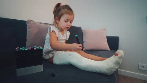 A child with a broken leg draws with col... | Stock Video | Pond5