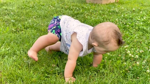 child crawling on the grass in the park.... | Stock Video | Pond5