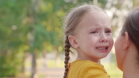Child is crying in park in arms of mom. ... | Stock Video | Pond5