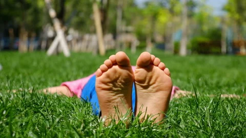 Child feet on the grass. Selective focus... | Stock Video | Pond5
