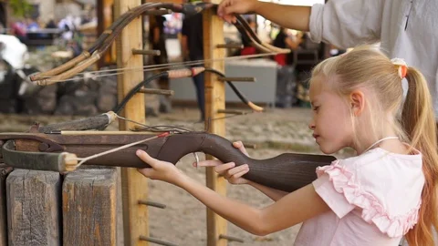 Child girl aims and shoots with crossbow... | Stock Video | Pond5