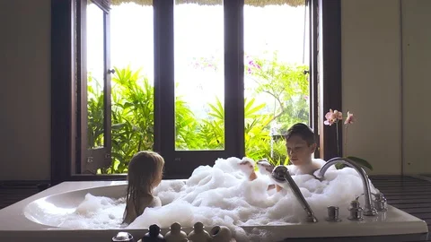 Child girl and boy taking bath with sham... | Stock Video | Pond5