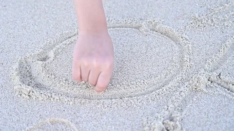child hand drawing with finger on sand b... | Stock Video | Pond5