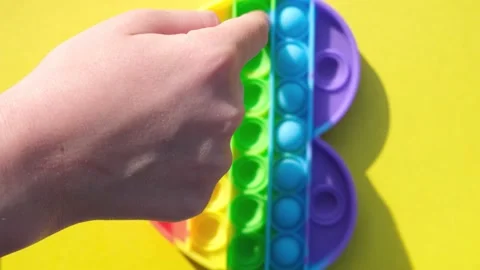 Child Hands Playing with a Popit on Yell... | Stock Video | Pond5