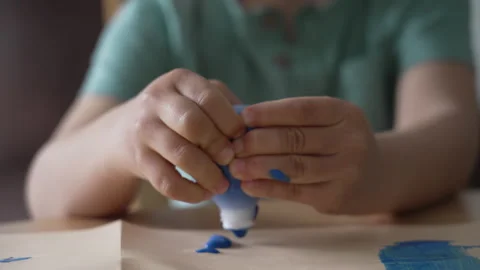 Child hands pressing coloring paint tube... | Stock Video | Pond5