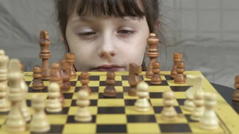 Child learn playing chess alone. | Stock Video | Pond5