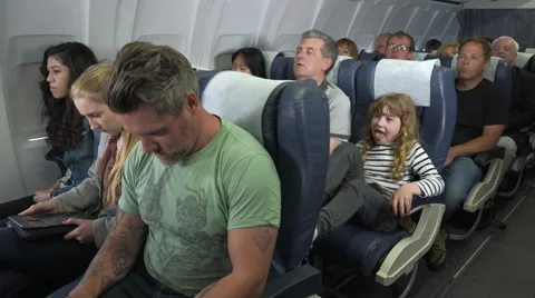 Child on plane is kicking the seat of an... | Stock Video | Pond5