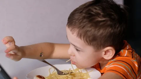 child playing with pasta at dining table... | Stock Video | Pond5