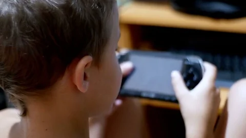 Child is Playing in a Portable Game Cons... | Stock Video | Pond5