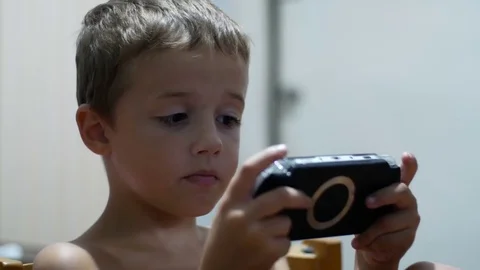 Child is Playing in a Portable Game Cons... | Stock Video | Pond5