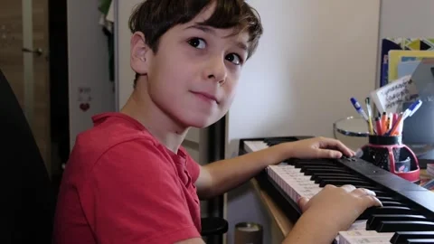 A child practices on a keyboard piano at... | Stock Video | Pond5
