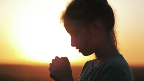 Child praying at sunset, thank God. Silh... | Stock Video | Pond5