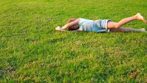 child rolls down the hill on the grass. ... | Stock Video | Pond5