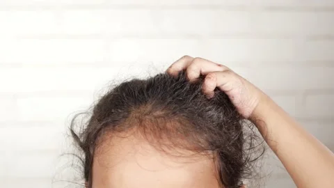 child Scratching Head Against white wall | Stock Video | Pond5