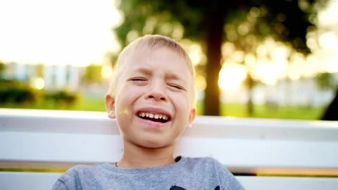 Child sits on park bench and crying. Clo... | Stock Video | Pond5