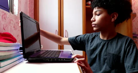 Child sitting down at desk opens laptop ... | Stock Video | Pond5