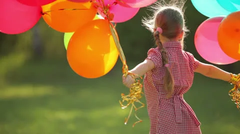 Child spinning with balloons in the park... | Stock Video | Pond5
