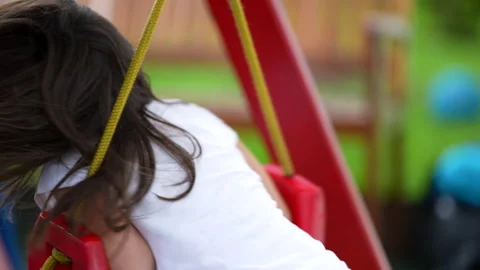 Child twisting at swing little girl turn... | Stock Video | Pond5