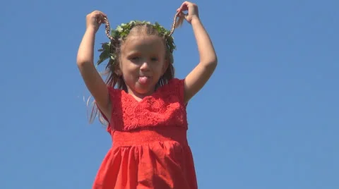 Child with Wreath Making Faces on Blue S... | Stock Video | Pond5