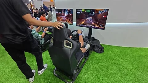 Children are engrossed in a car race sim... | Stock Video | Pond5