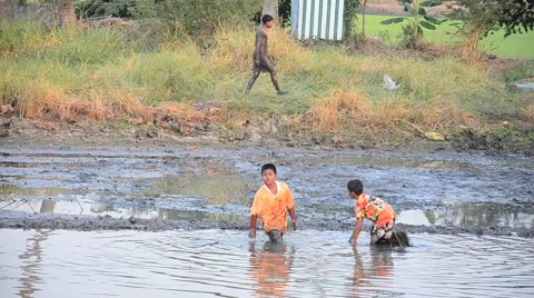 Children catch fish in mud of pond at Co... | Stock Video | Pond5