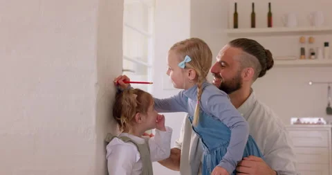 Children check height growth with father... | Stock Video | Pond5