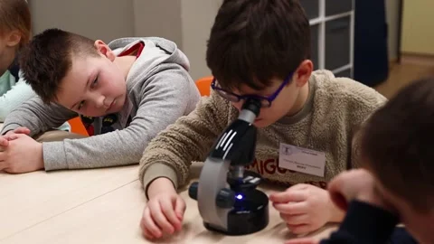 Children examine body cells through a mi... | Stock Video | Pond5