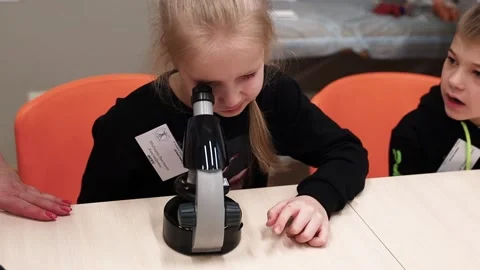 Children examine body cells through a mi... | Stock Video | Pond5