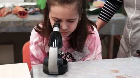 Children examine body cells through a mi... | Stock Video | Pond5