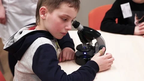 Children examine body cells through a mi... | Stock Video | Pond5