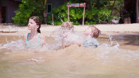 Children Getting Splashed By Waves On A ... | Stock Video | Pond5