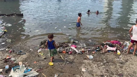 Children play and swim in dirty polluted... | Stock Video | Pond5