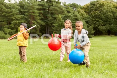 Photograph: Children playing with hoppers and hoop at park #165208077
