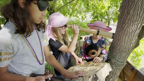 Children playing pirate in tree reading ... | Stock Video | Pond5
