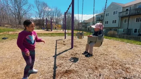 Children Ride on a Swing in the Playgrou... | Stock Video | Pond5