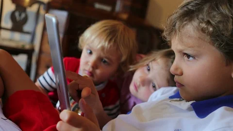 Children starring at tablet screen devic... | Stock Video | Pond5