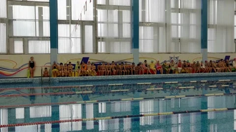 Children swimmers sit on a bench along t... | Stock Video | Pond5
