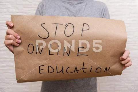 A childs hands holding a banner with a sign stop online education ...