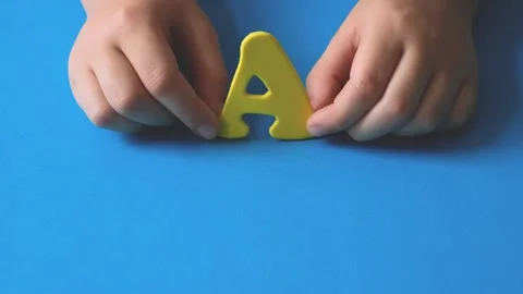 The child's hands wave the letter A. Yel... | Stock Video | Pond5