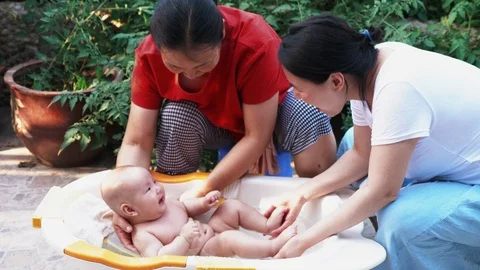 Chinese newborn baby taking Bath in yard... | Stock Video | Pond5