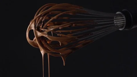Chocolate dripping from whisk on a black... | Stock Video | Pond5
