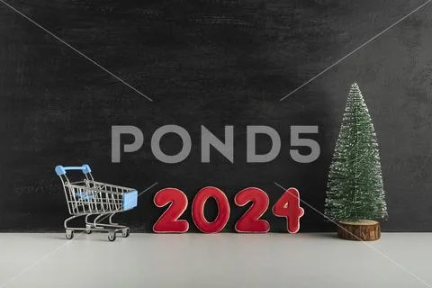 Photograph: Christmas tree, trolley cart and numbers 2024 on dark ...