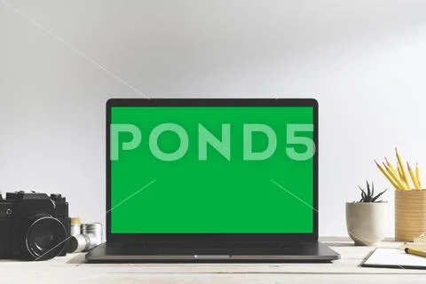 Chroma key green screen laptop on table with a film camera. ~ Premium ...
